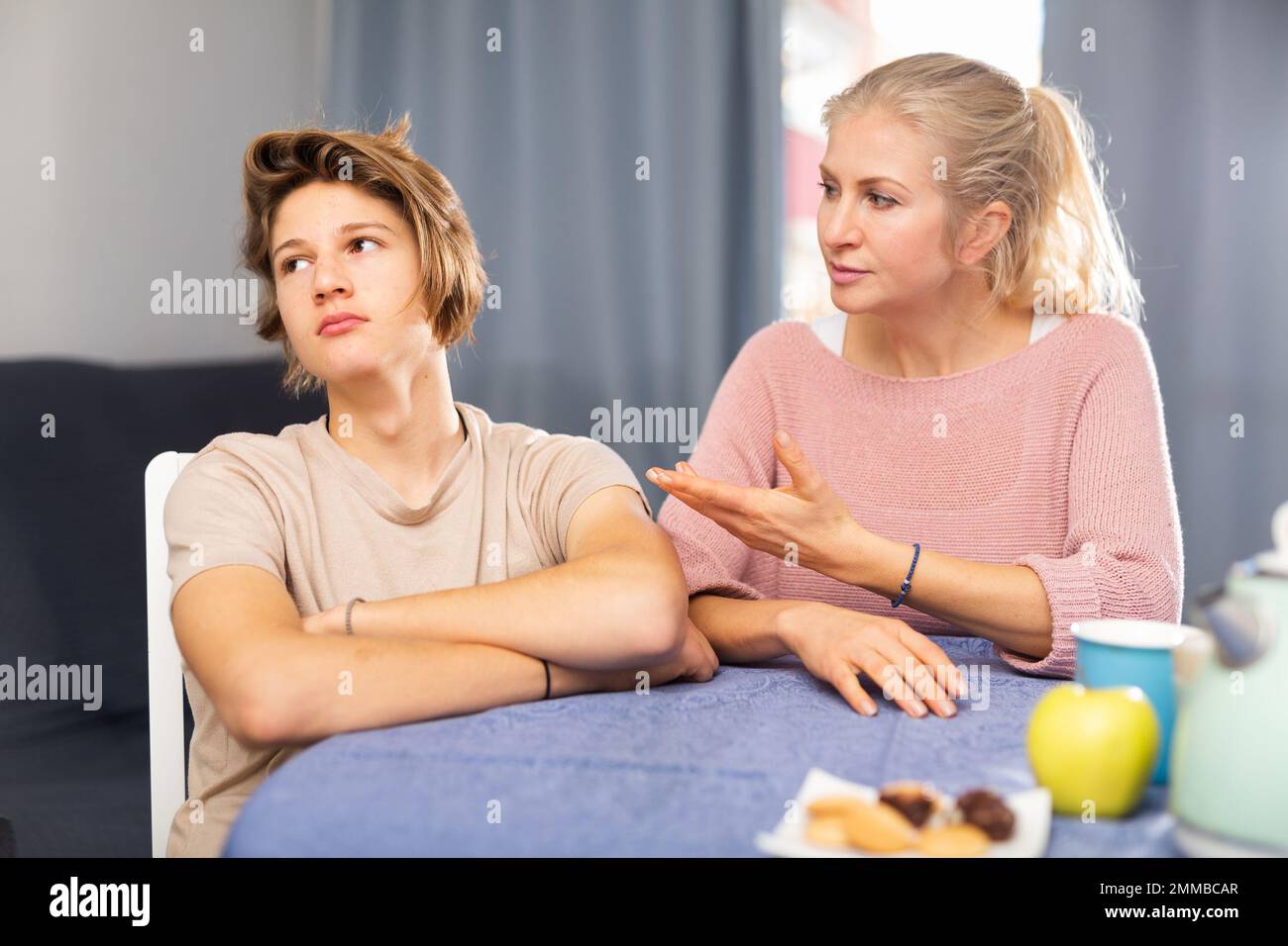 Caring mother soothing upset teenage boy at home table Stock Photo - Alamy