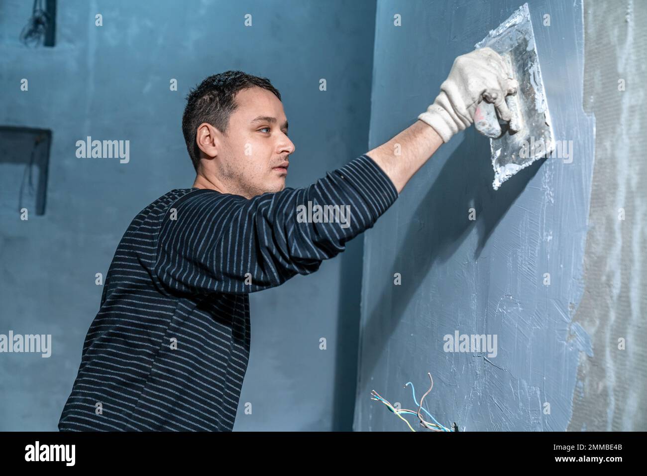man applies insulation to a bathroom wall Stock Photo - Alamy