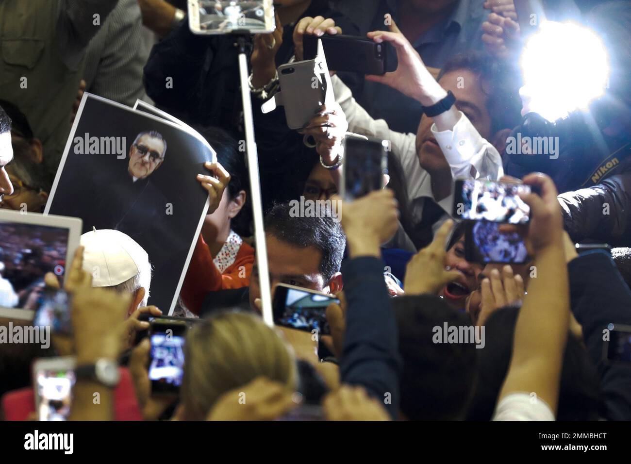 Pope Francis, white cap seen at left, is surrounded by faithful as he ...