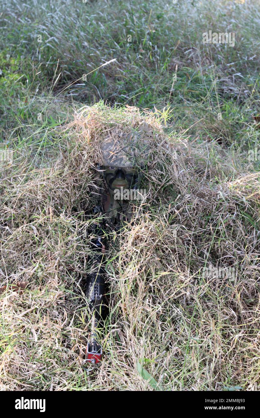Army soldiers camouflaged in grass with weapons during Basic Combat ...