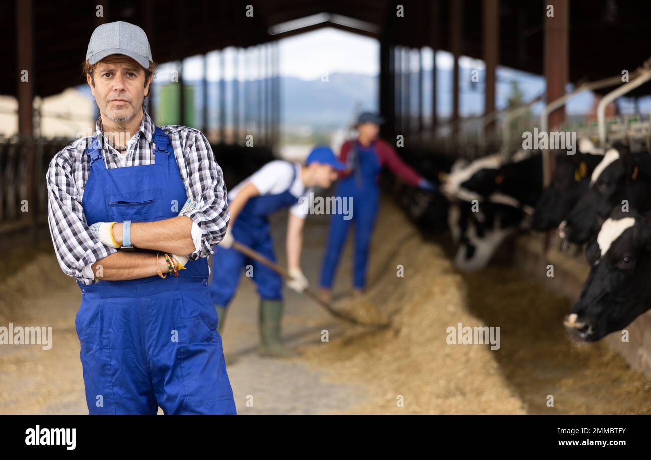 Male farmer is standing at cow farm Stock Photo - Alamy