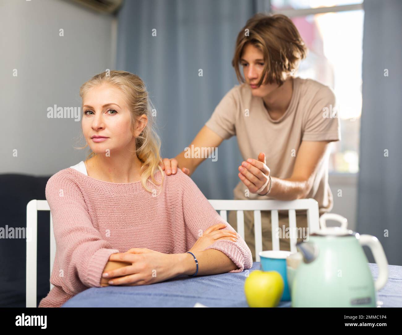 Teenage boy asking for forgiveness from upset mother Stock Photo - Alamy