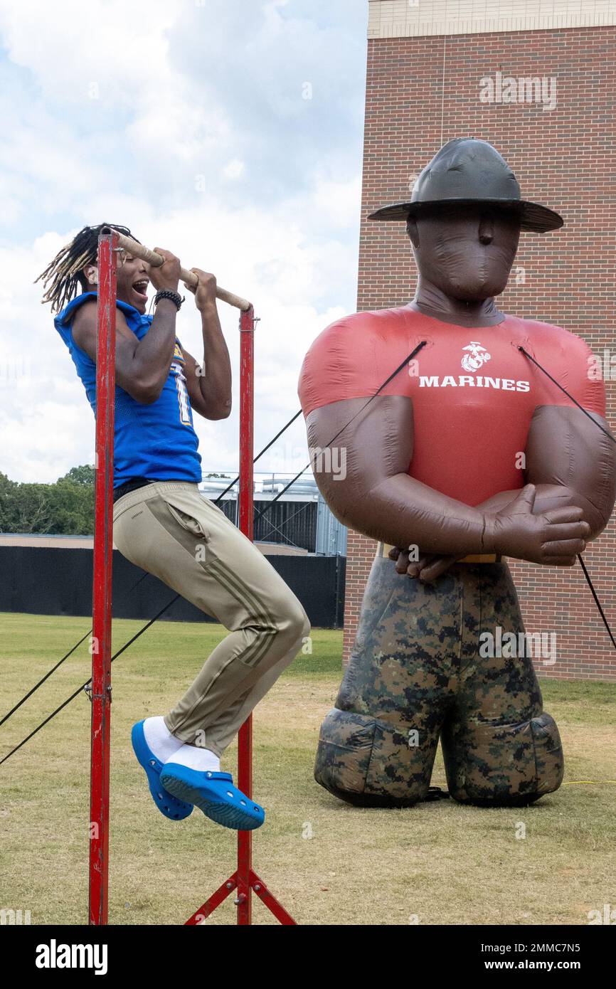 An Oxford High School football player performs pull-ups to contribute ...