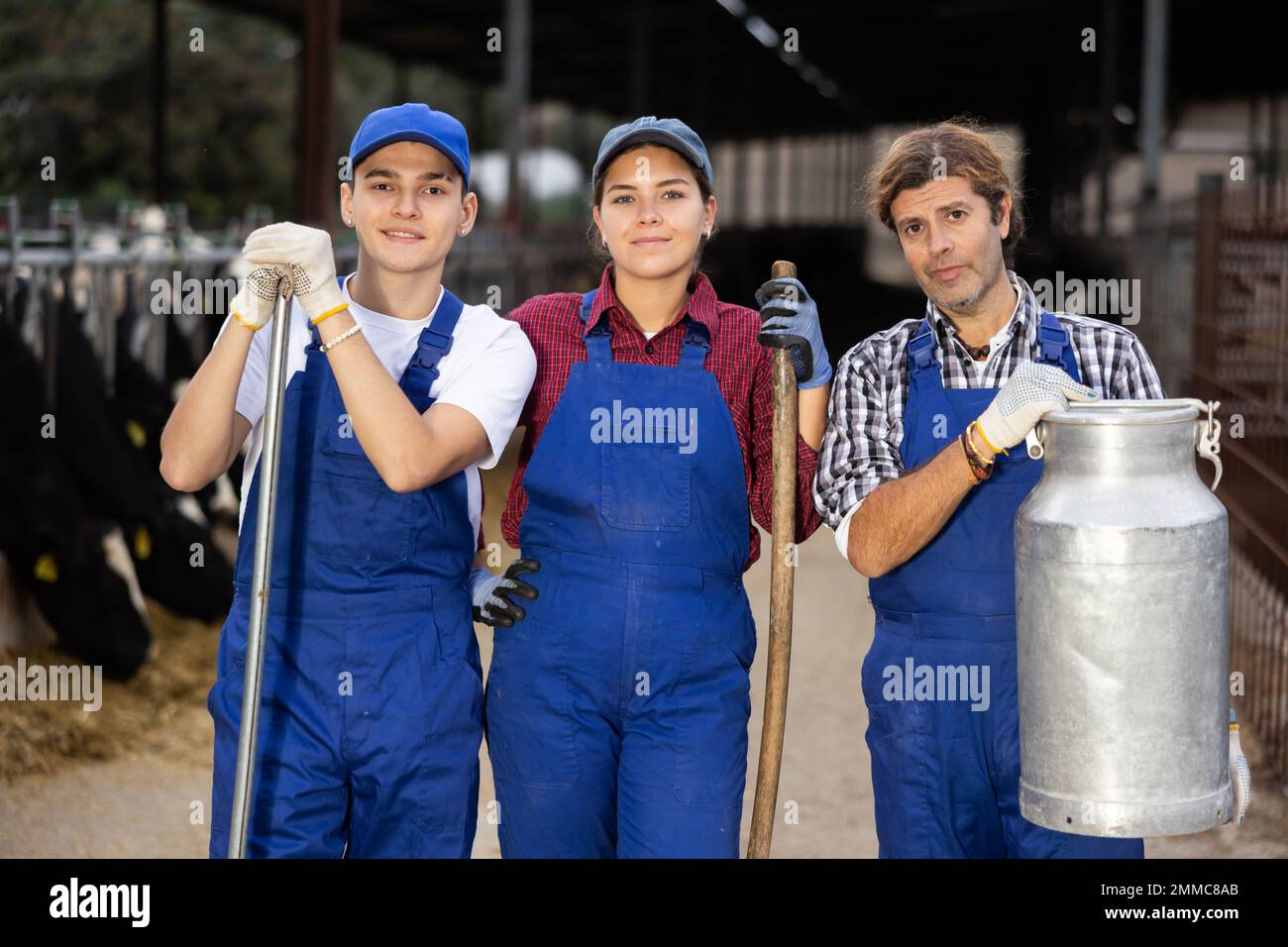 Successful adult dairy farm owner with guy and young female posing ...
