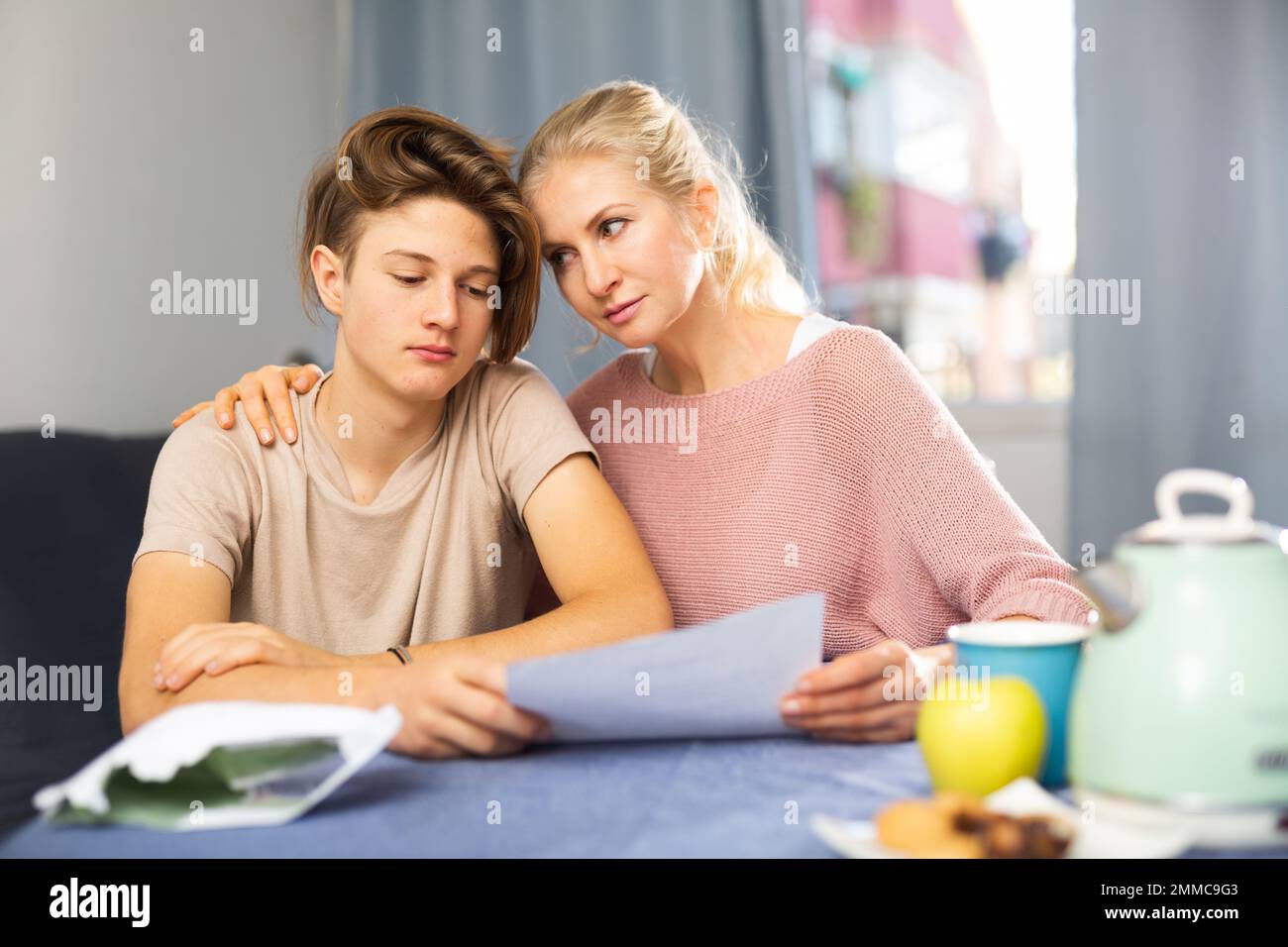 Caring mother calming upset teenage son student receiving test failure ...