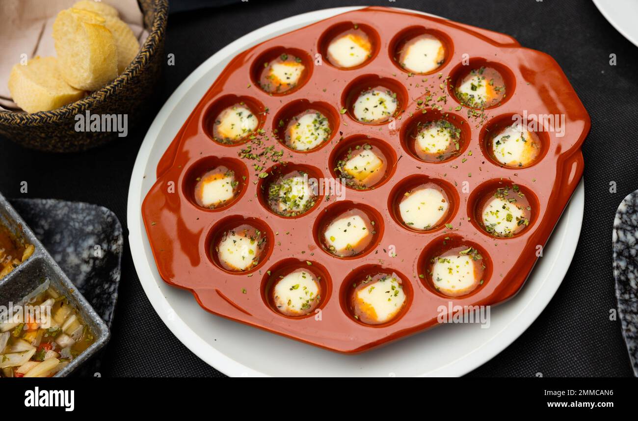 Baked Provolone cheese slices with spicy sauce and dried herbs Stock ...