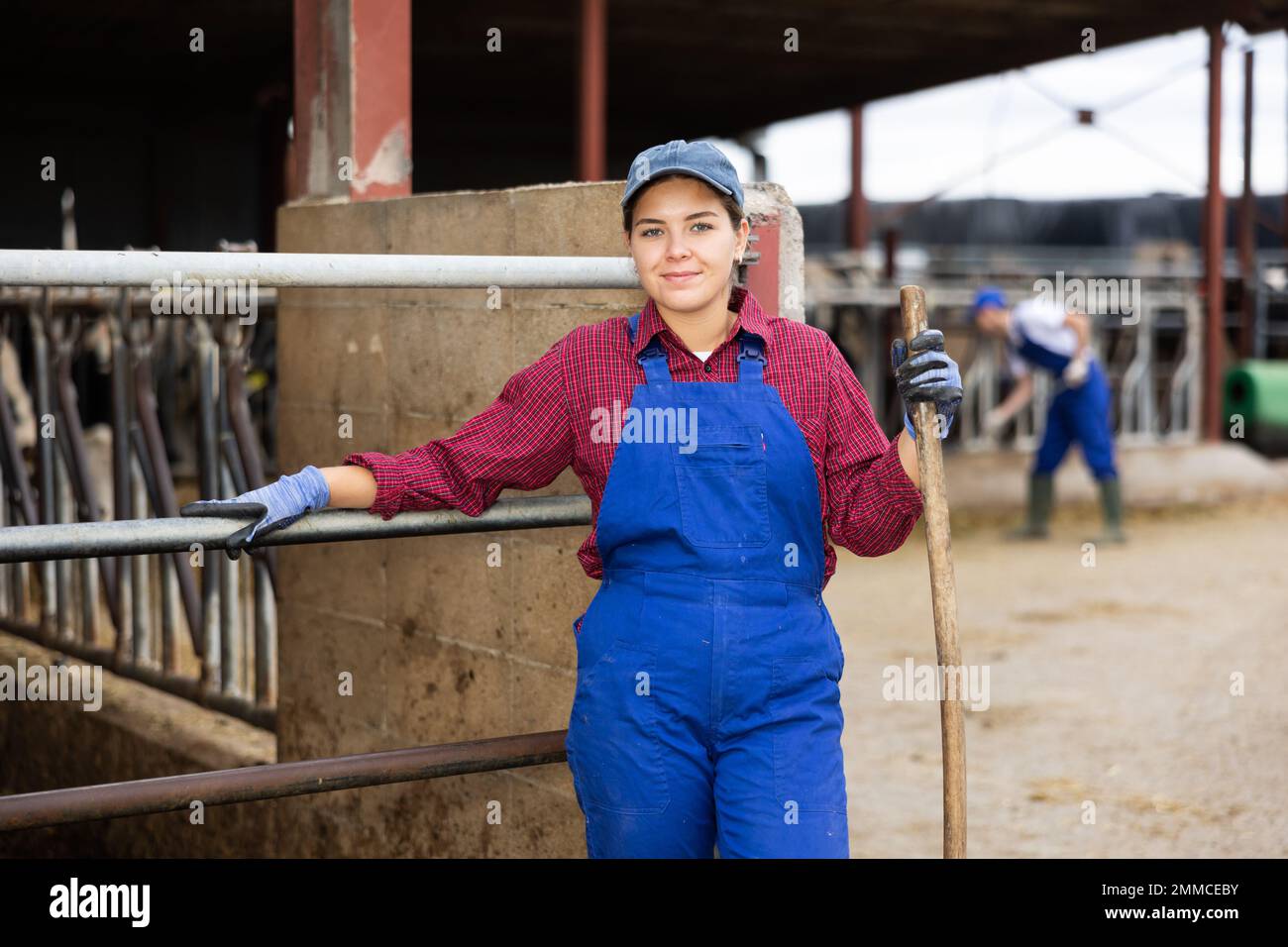Farmer woman stands with rake at cow farm Stock Photo - Alamy