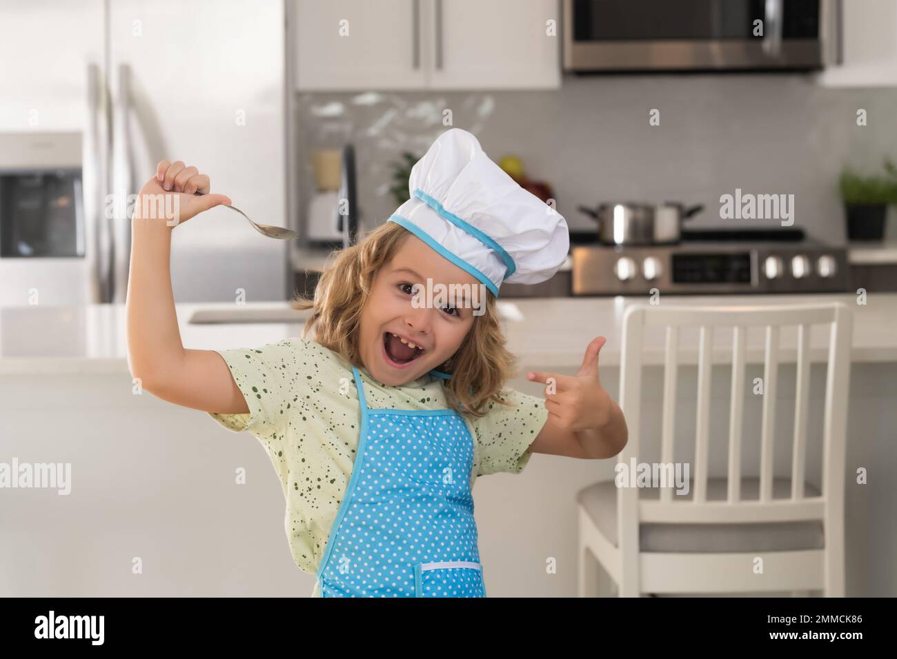 Kid chef cook wearing cooker uniform and chef hat preparing food on ...