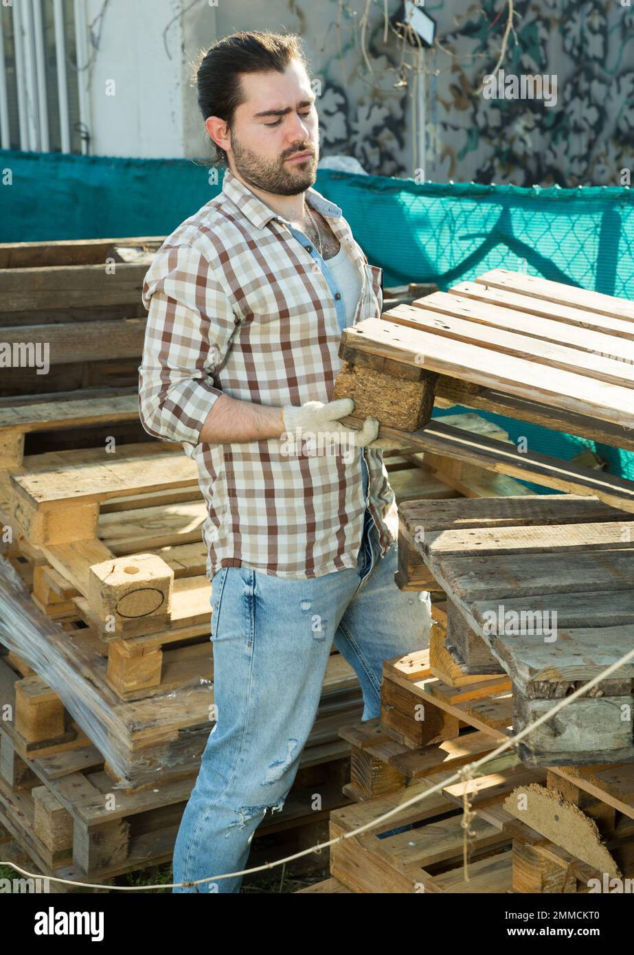Man working with wooden pallets Stock Photo - Alamy