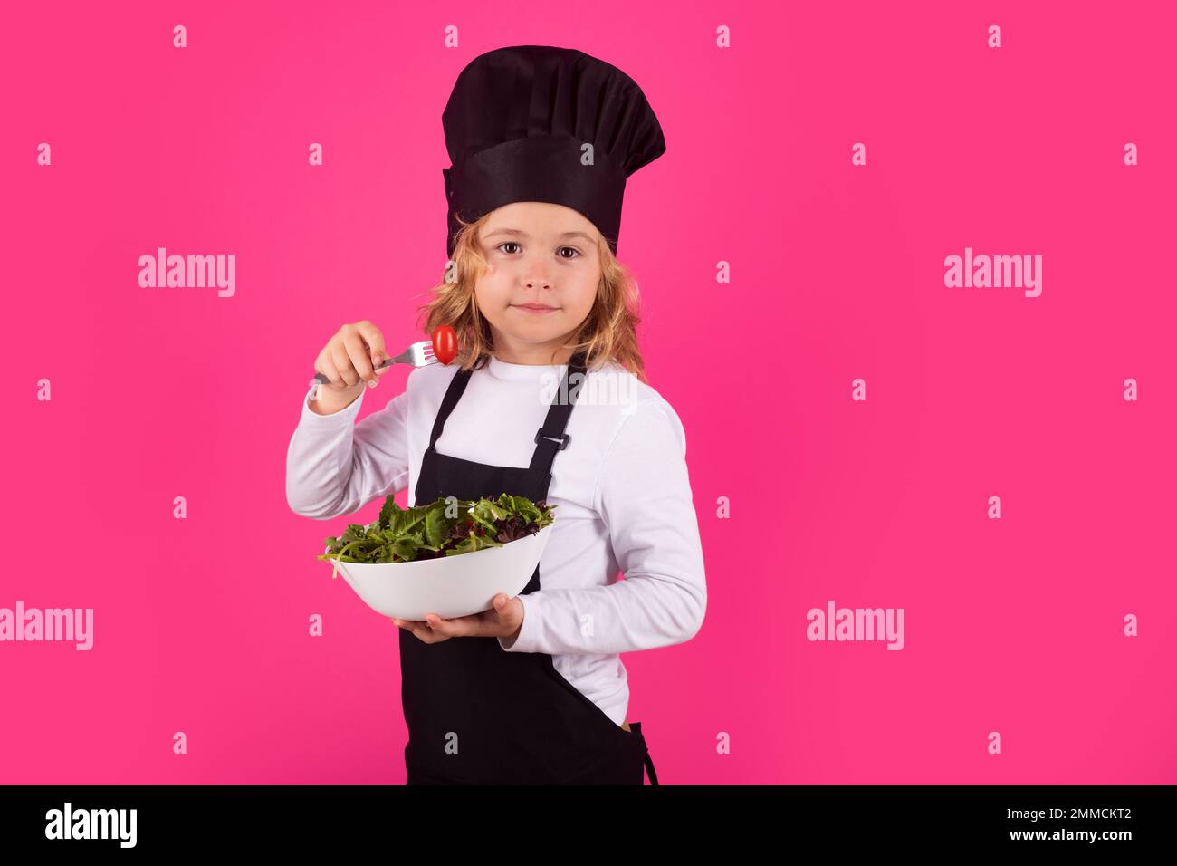 Kid cook hold plate with vegetables and fork with tomato. Cooking ...