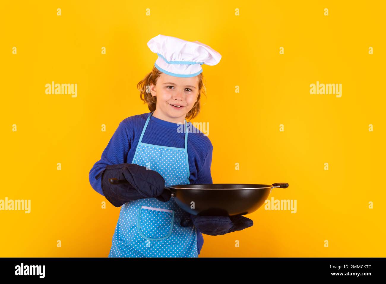 Child chef cook with cooking pan. Child chef cook prepares food on ...