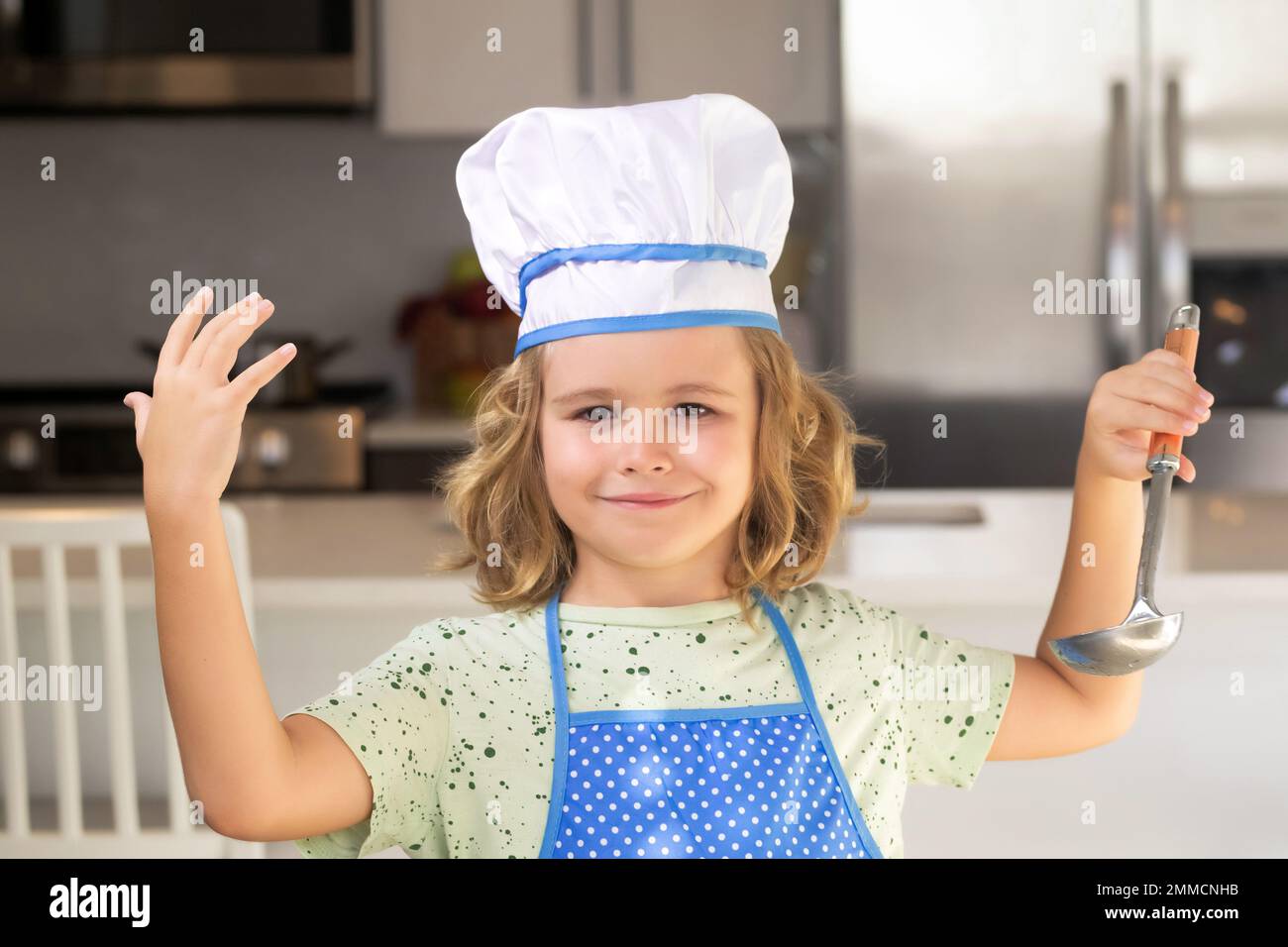 Child chef cook. Funny child stand at kitchen table have fun baking ...
