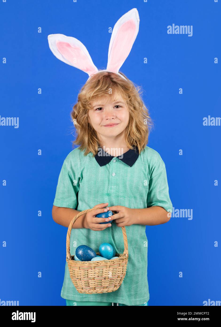 Portrait of child with bunny ears hold easter basket with easter eggs ...