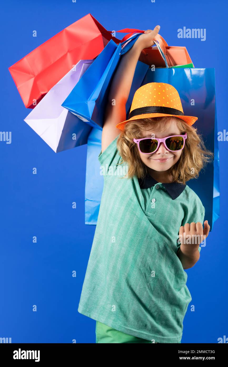 Discounts and sales. Happy Kid boy with shopping bags. Kid with ...