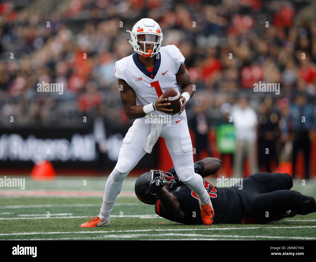 Illinois quarterback AJ Bush Jr. gets away from Rutgers defender Jon ...
