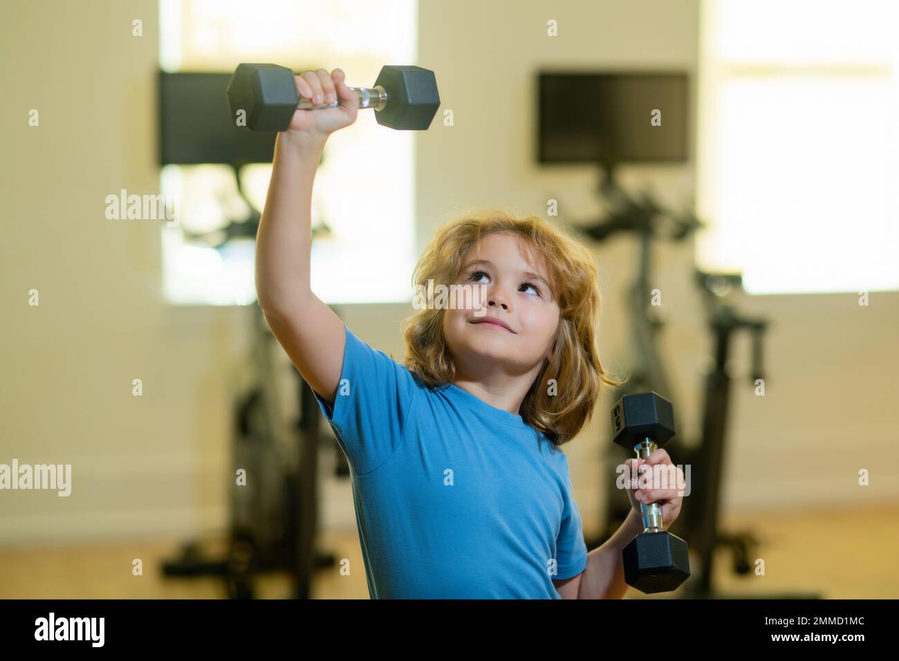 Child boy working out with dumbbells. Kids sport and active healthy ...