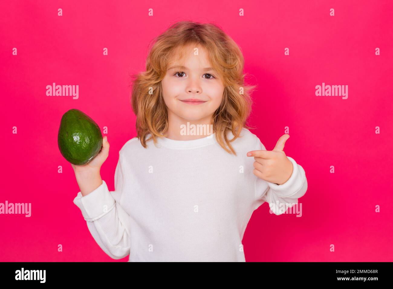 Kid hold red avocado in studio. Studio portrait of cute child with ...