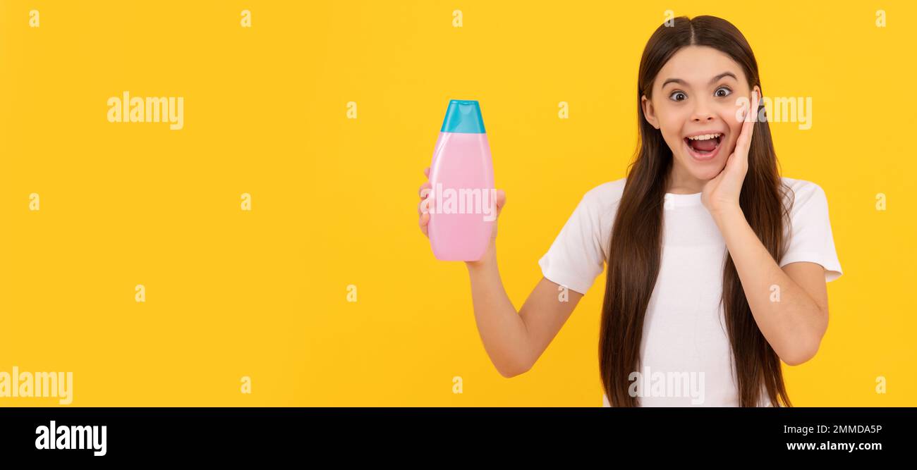 surprised teen girl long hair with body lotion on yellow background ...