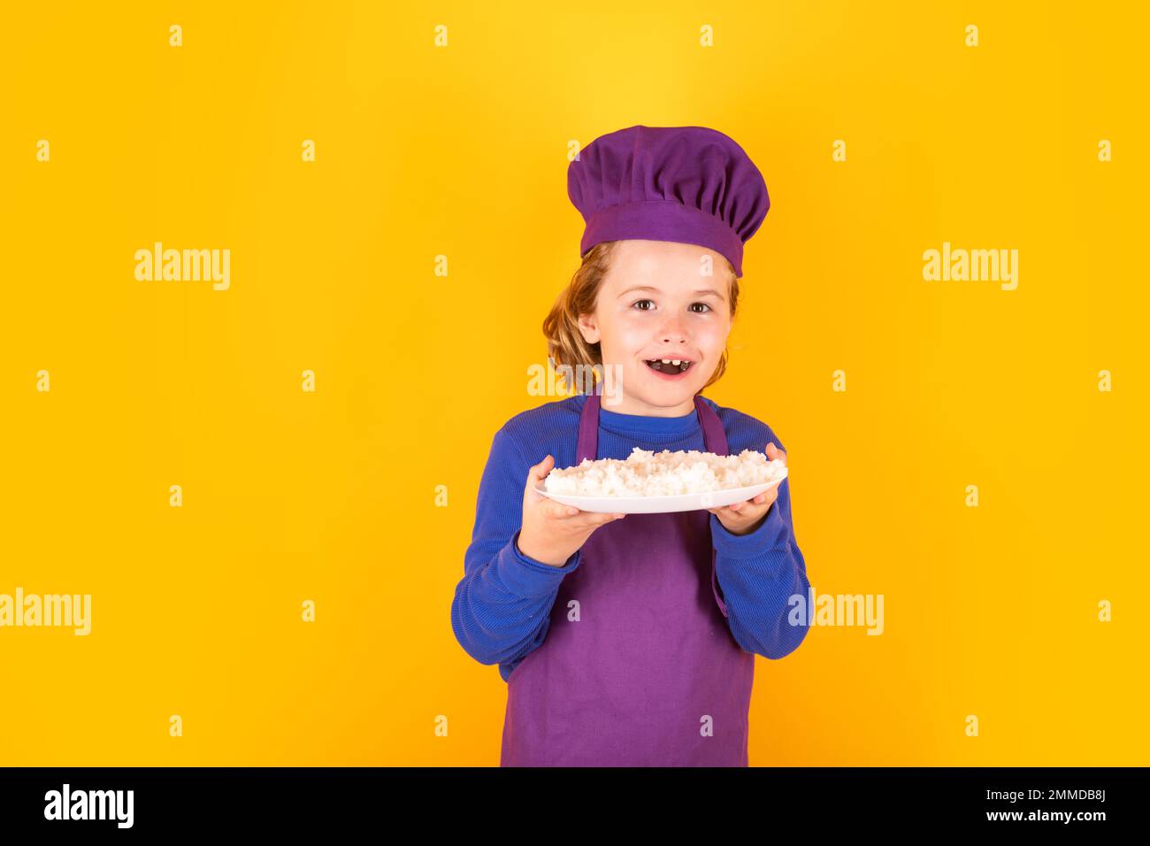 Cooking, culinary and kids. Little boy in chefs hat and apron on studio ...