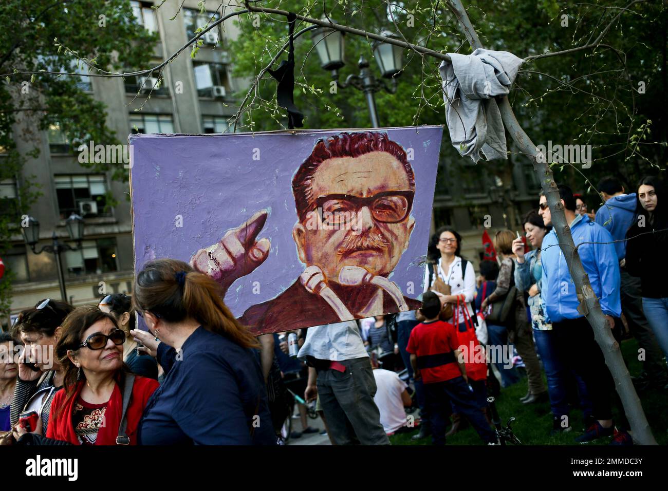 People hold a painting of Chile's deposed president Salvador Allende ...