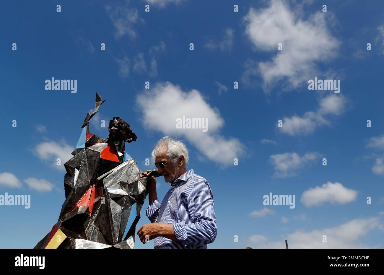 Sculptor Jim Bliesner stands next to a scaled-down version of "Welcome ...