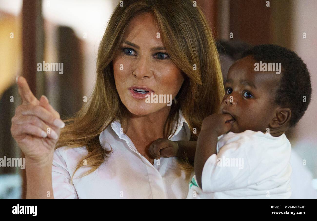 First lady Melania Trump holds a baby as she visits the Nest Orphanage ...