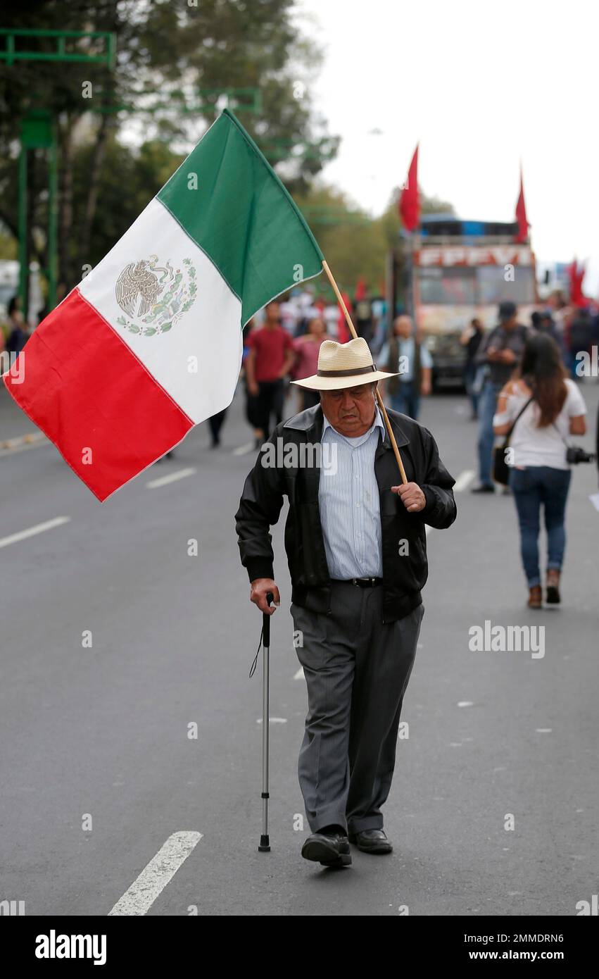 A man walk with a Mexican flag as demonstrators march in remembrance of ...
