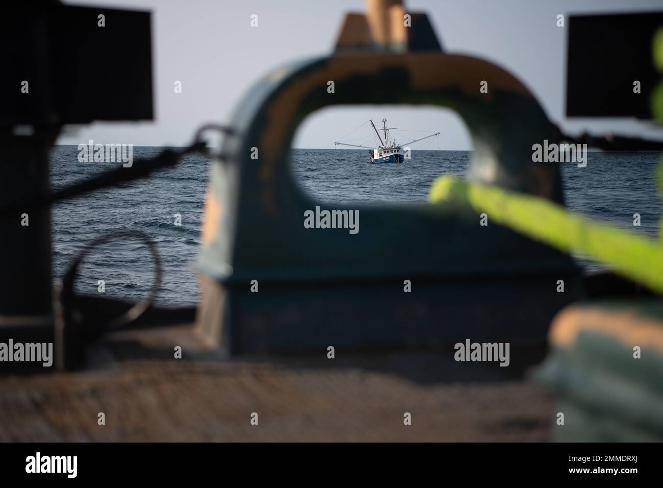 A disabled fishing vessel is seen in tow through the aft chock aboard ...
