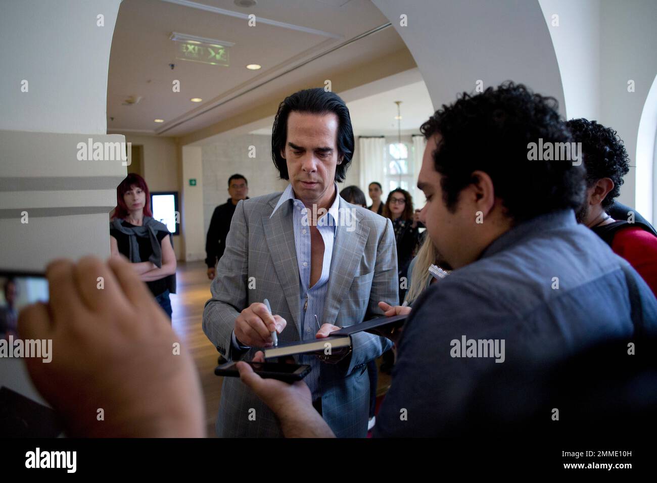 Australian rock musician Nick Cave signs his autograph for a fan at the ...