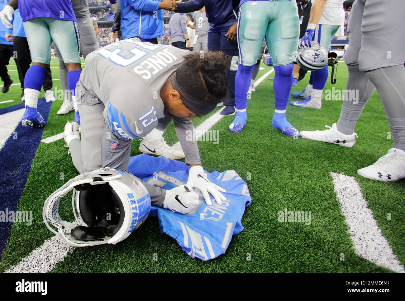 Detroit Lions wide receiver T.J. Jones (13) autographs his jersey for a ...