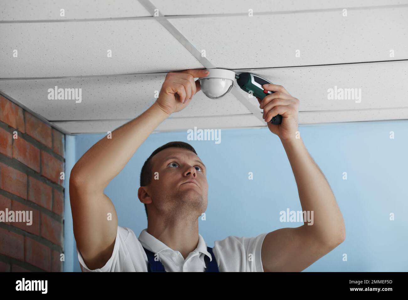 Technician installing CCTV camera on ceiling indoors Stock Photo - Alamy