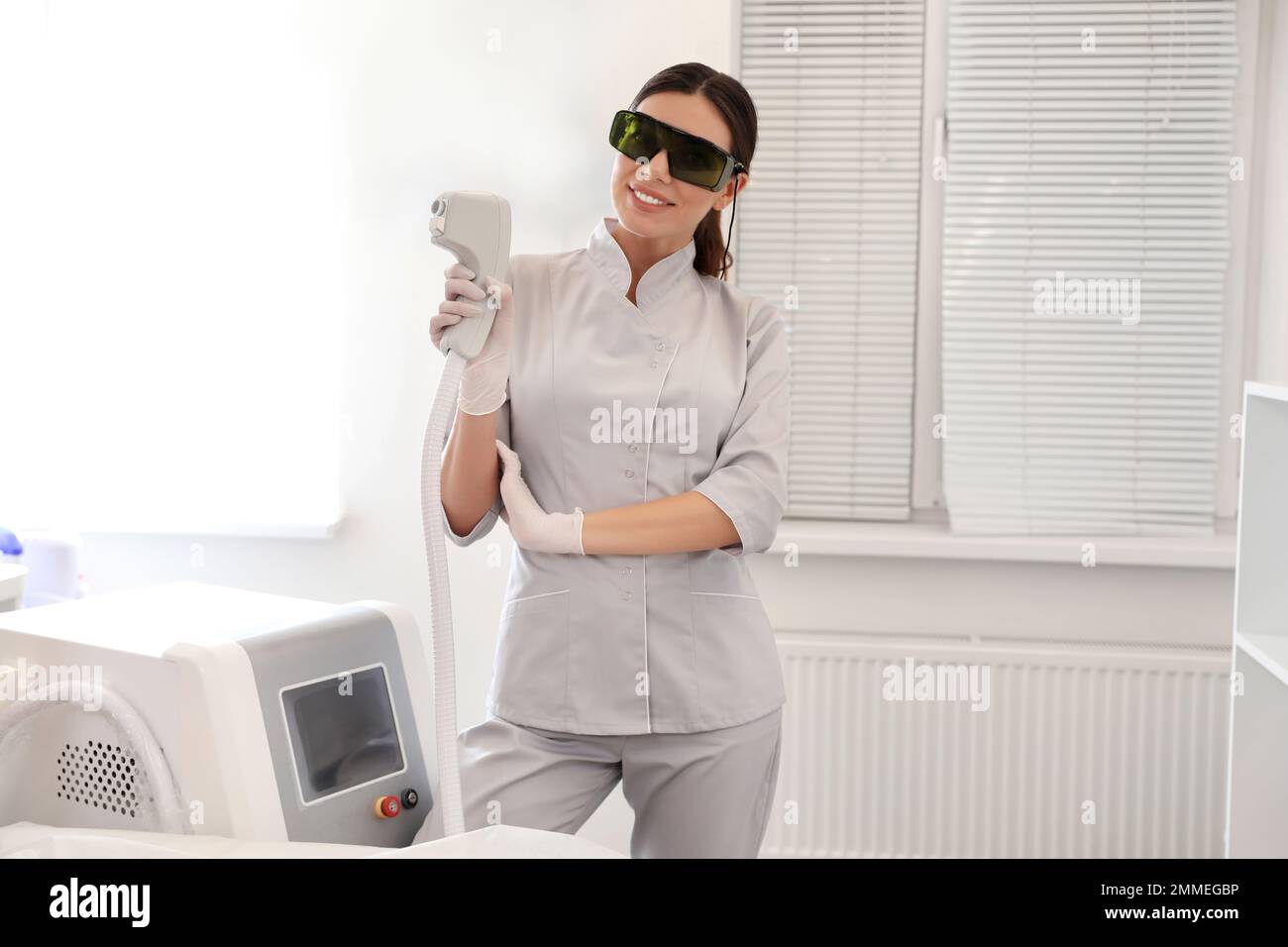 Young woman holding professional laser epilator in beauty salon Stock ...