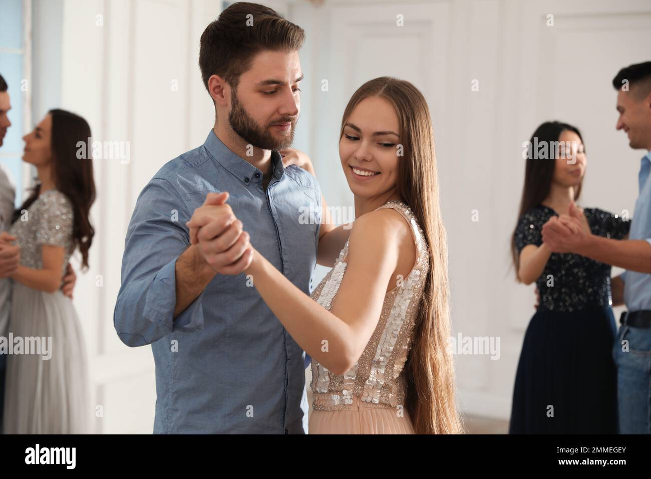 Lovely young couple dancing together at party Stock Photo - Alamy