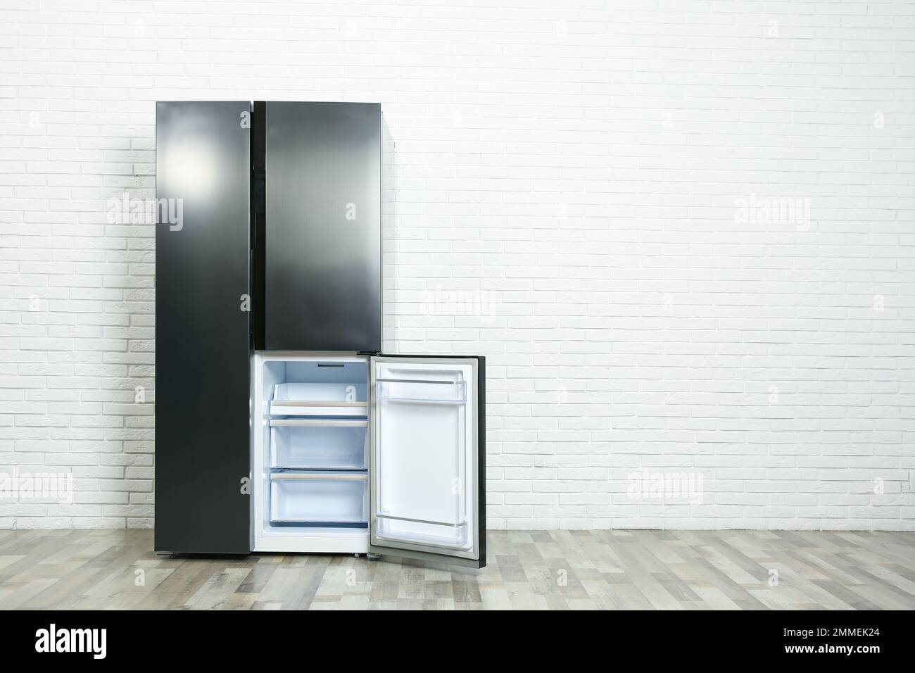 Modern empty refrigerator near white brick wall, space for text Stock ...