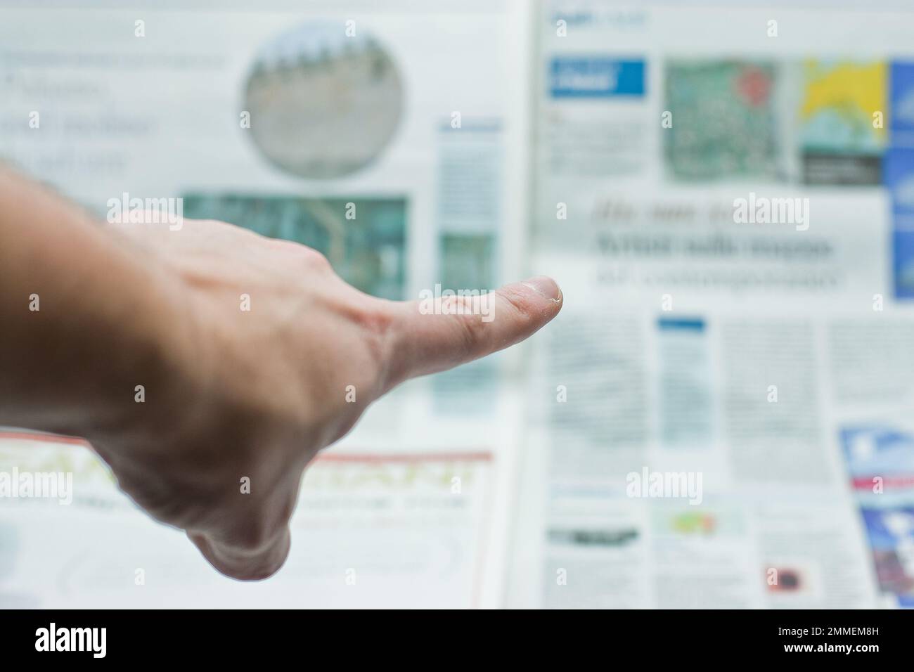 Finger of the hand pointing to the bottom of a newspaper article Stock ...