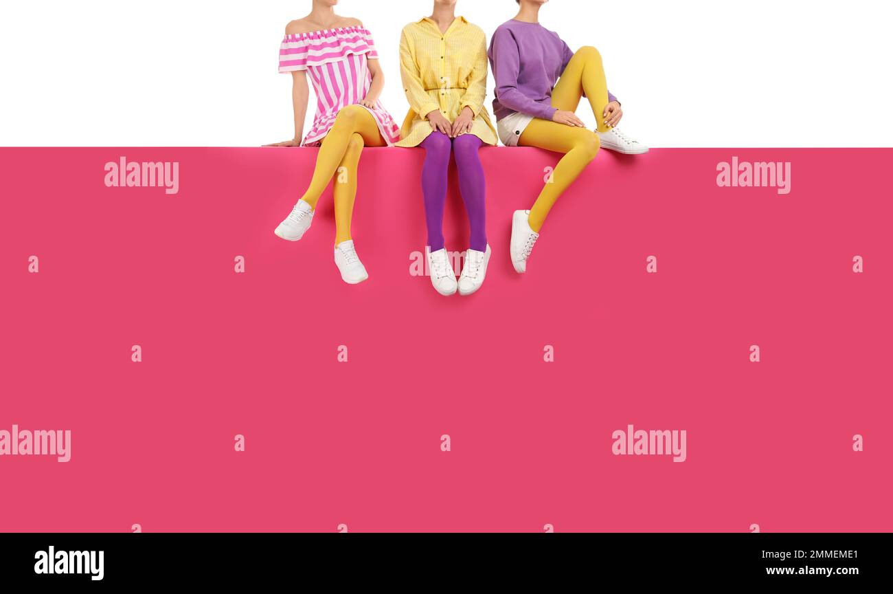 Group of women wearing bright tights and stylish shoes sitting on color ...