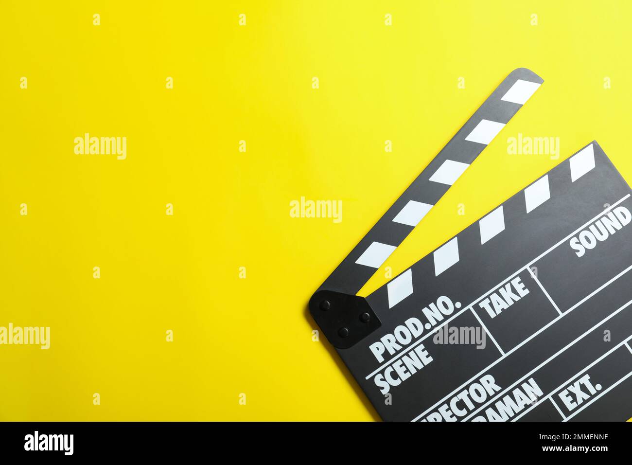 Clapper board on yellow background, top view with space for text ...