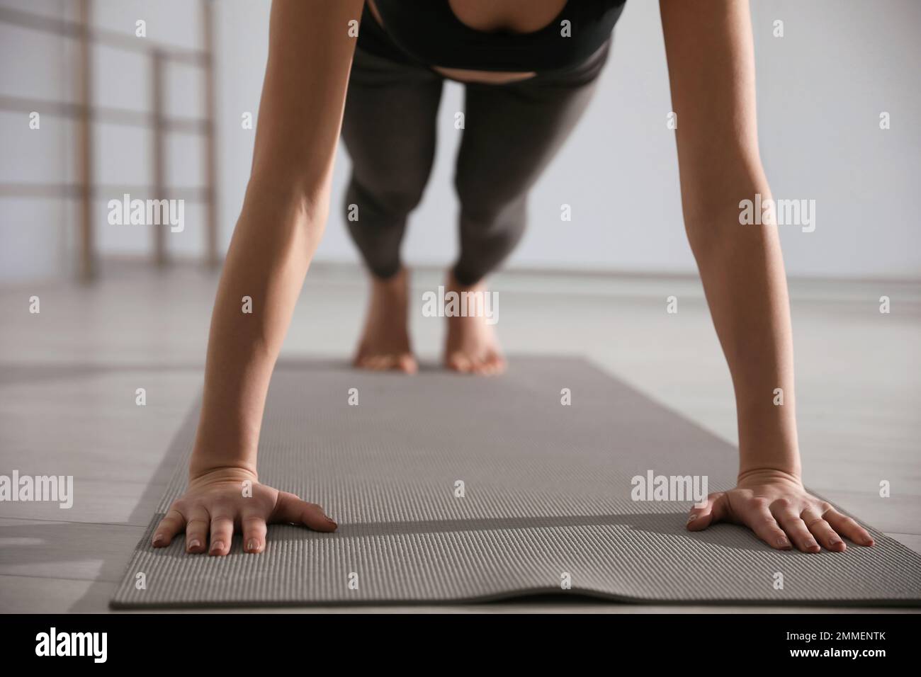 Young woman practicing plank asana in yoga studio, closeup ...