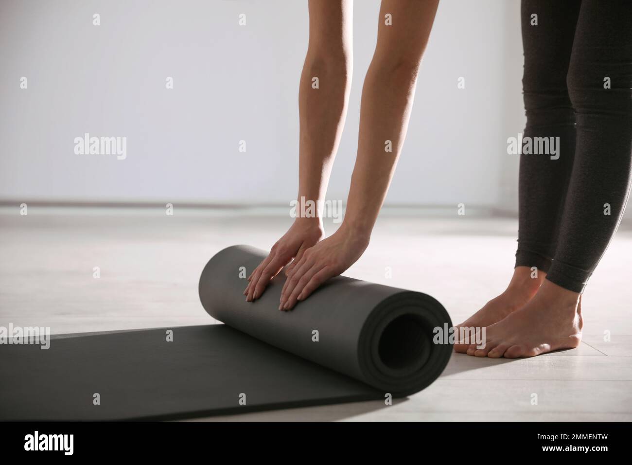 Woman rolling yoga mat in hi-res stock photography and images - Alamy
