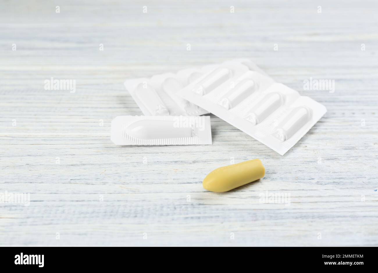 Suppositories on white wooden table. Hemorrhoid treatment Stock Photo ...