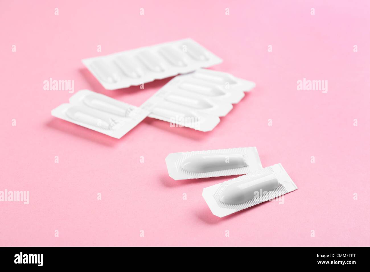 Suppositories on pink background, closeup view. Hemorrhoid treatment ...