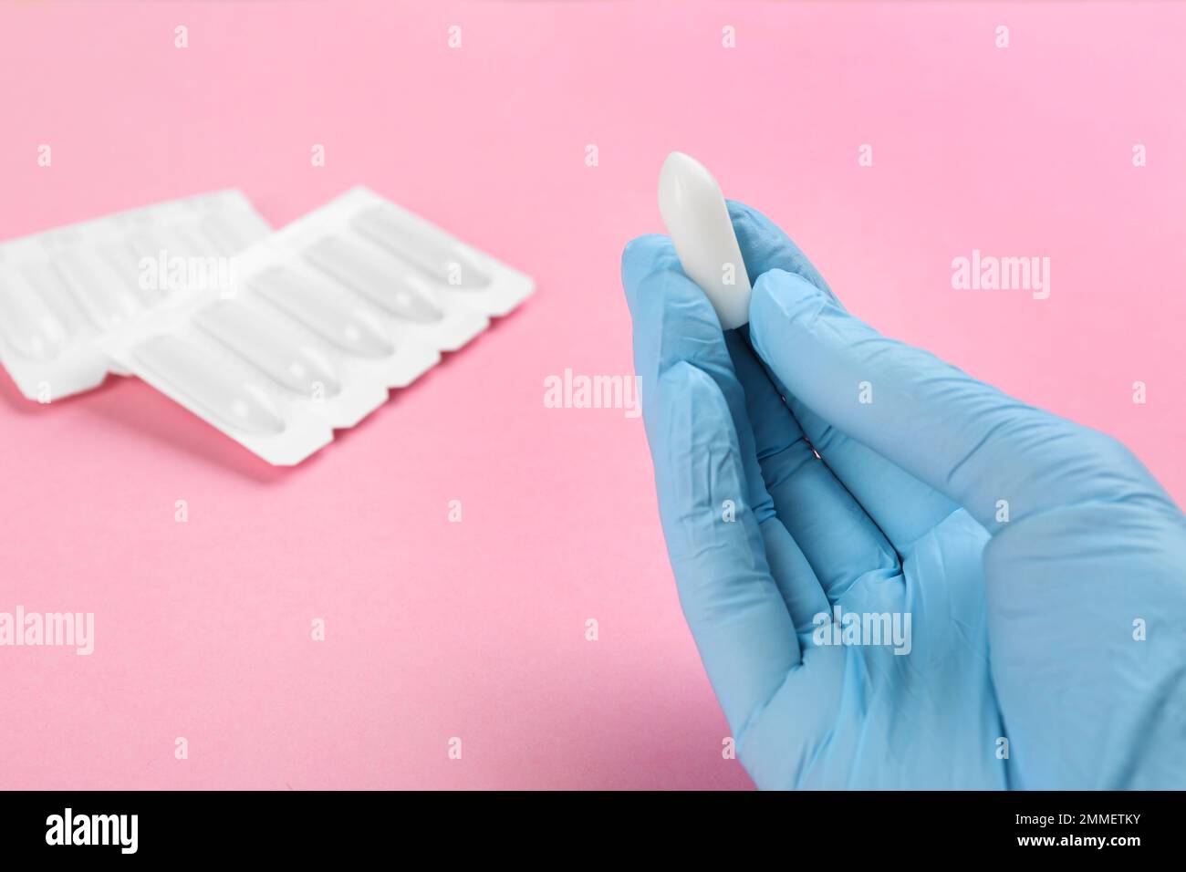 Woman holding suppository on pink background, closeup. Hemorrhoid ...