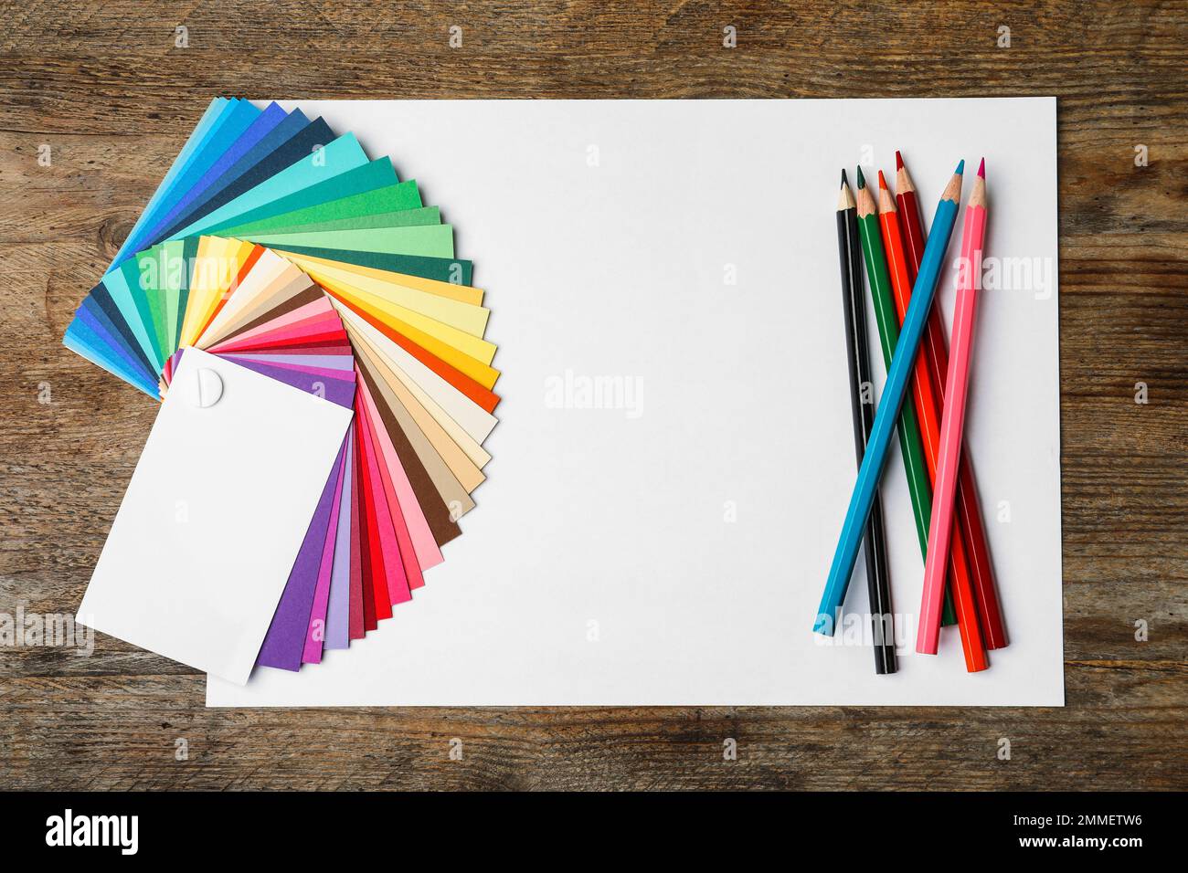 Color palette, pencils and blank paper sheet on wooden background, flat ...