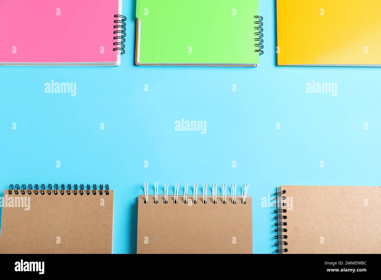 Flat lay composition with plastic and paper notebooks on light blue ...