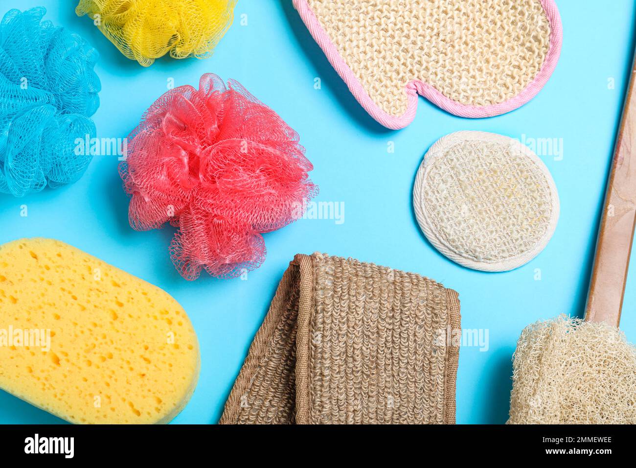 Flat lay composition with plastic and natural shower sponges on light ...