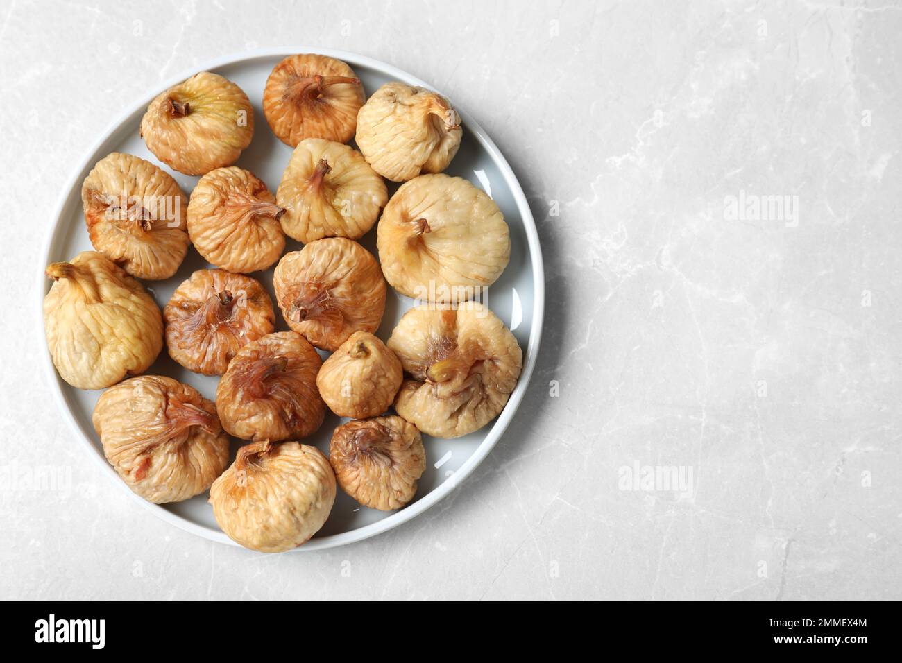 Tasty dried figs on light grey marble table, top view. Space for text ...