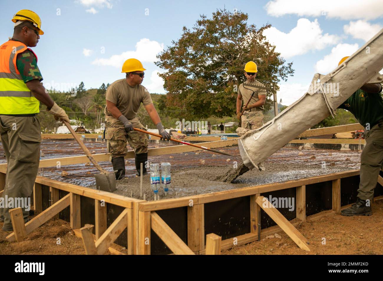 As the cement truck pours out concrete, members of 1st Platoon, 797th ...