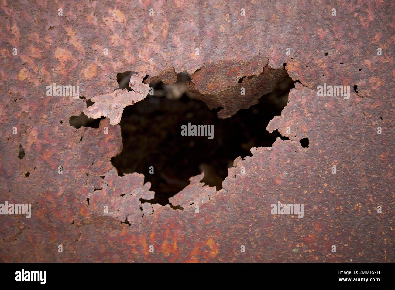 Rusted out metal with a ragged hole in the center Stock Photo - Alamy