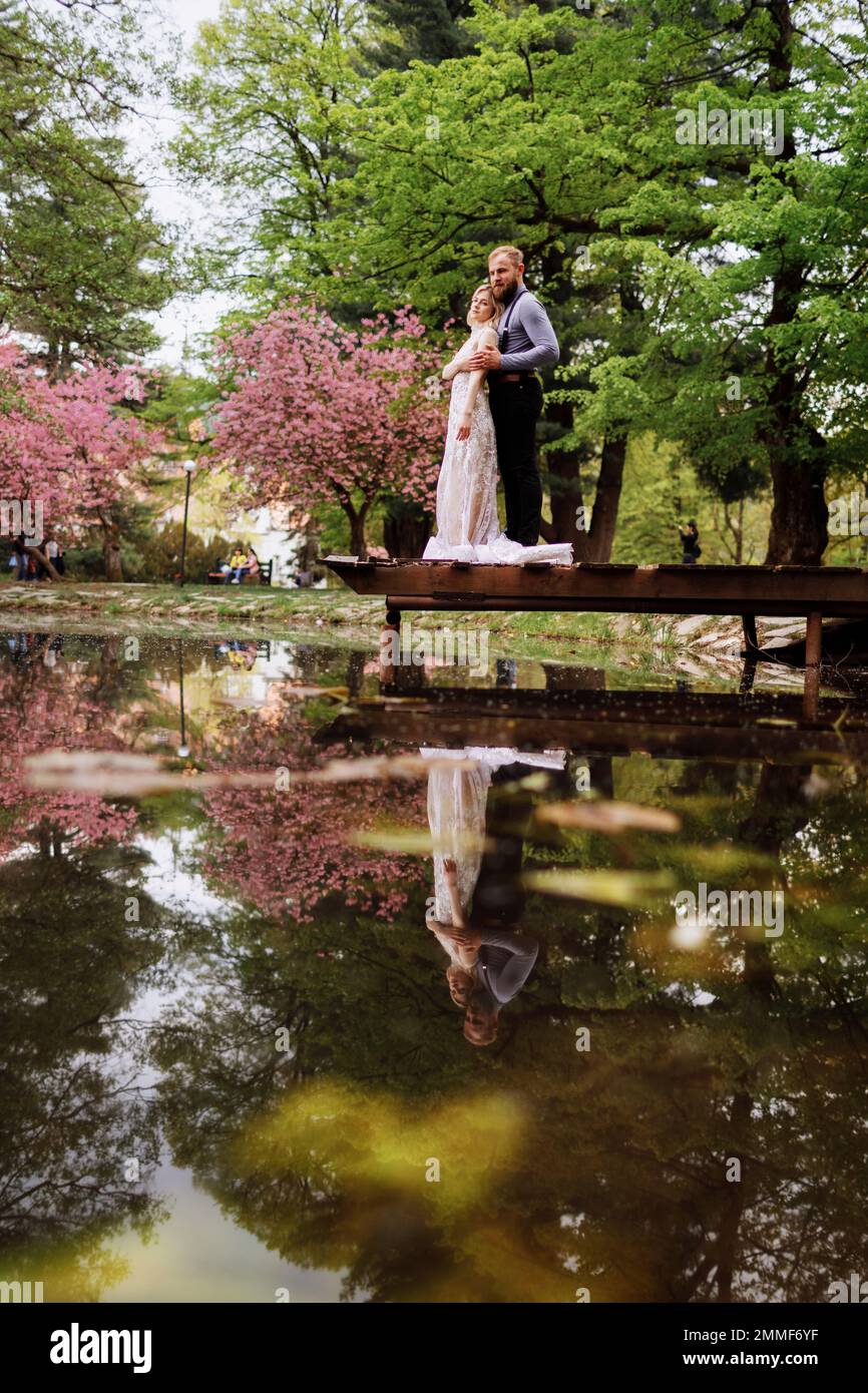 Beautiful, cheerful and lively newlyweds, groom and bride are hugging ...