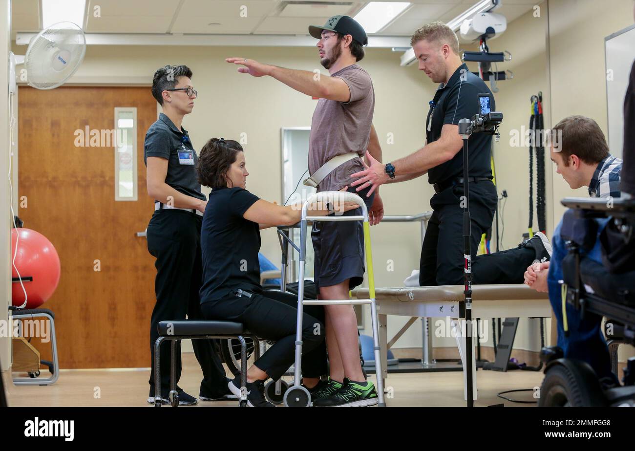 Jered Chinnock stands with the assistance of his therapy team at the ...